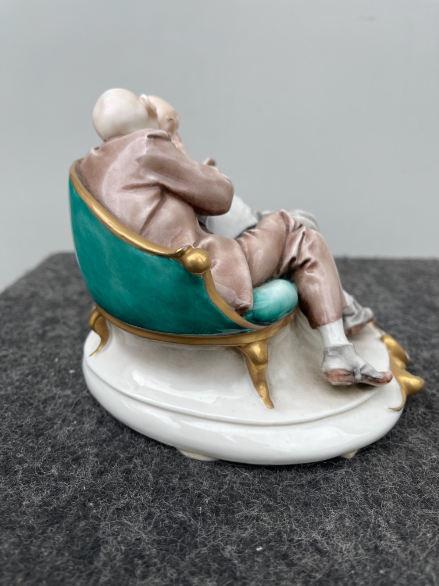 Polychrome porcelain sculpture depicting a man's head with a hat and ...